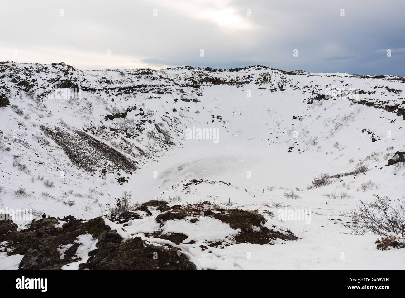 An expansive view of a snow-filled crater in Iceland, with rugged ...