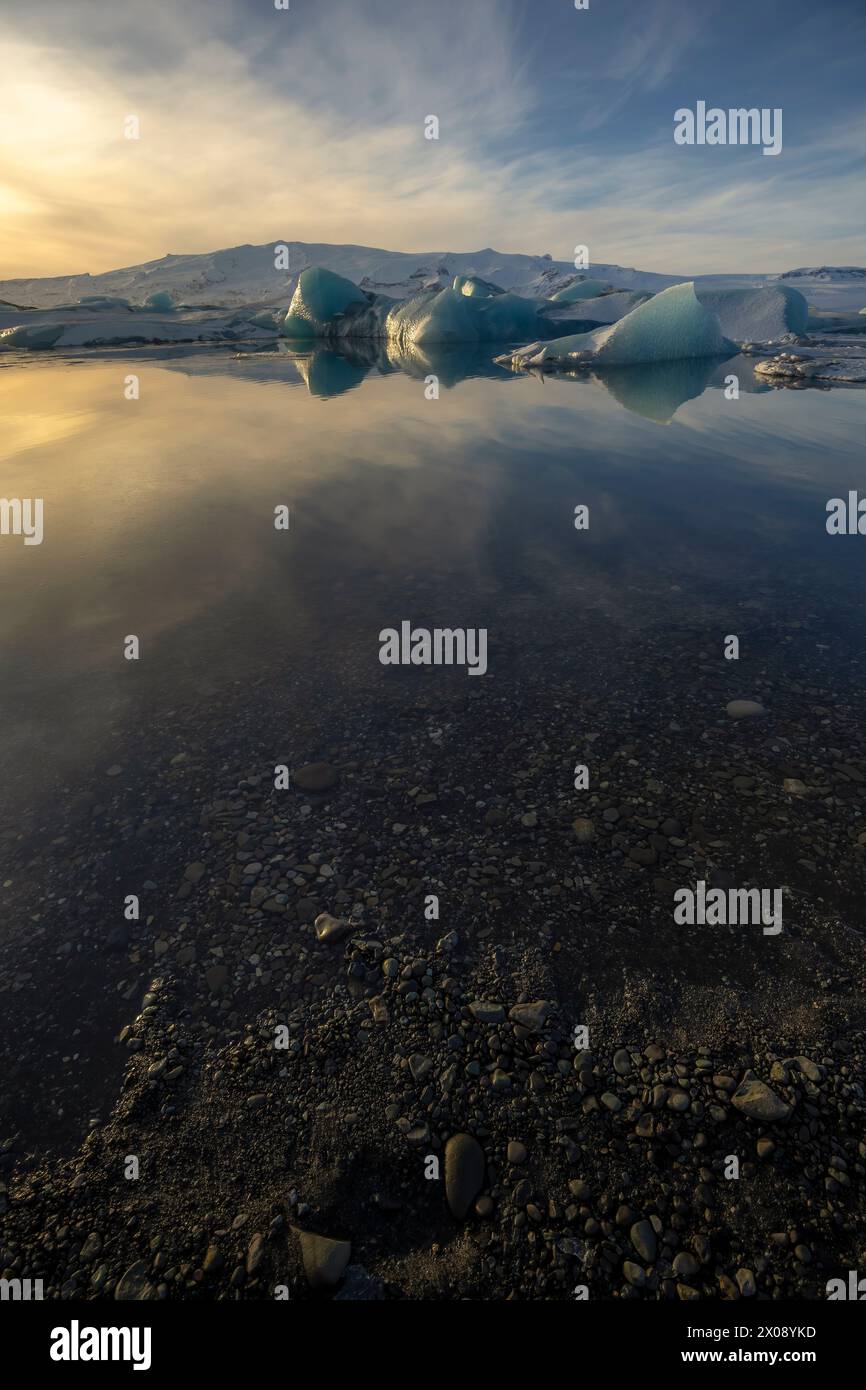 Vertical image capturing the serene beauty of icebergs and their ...