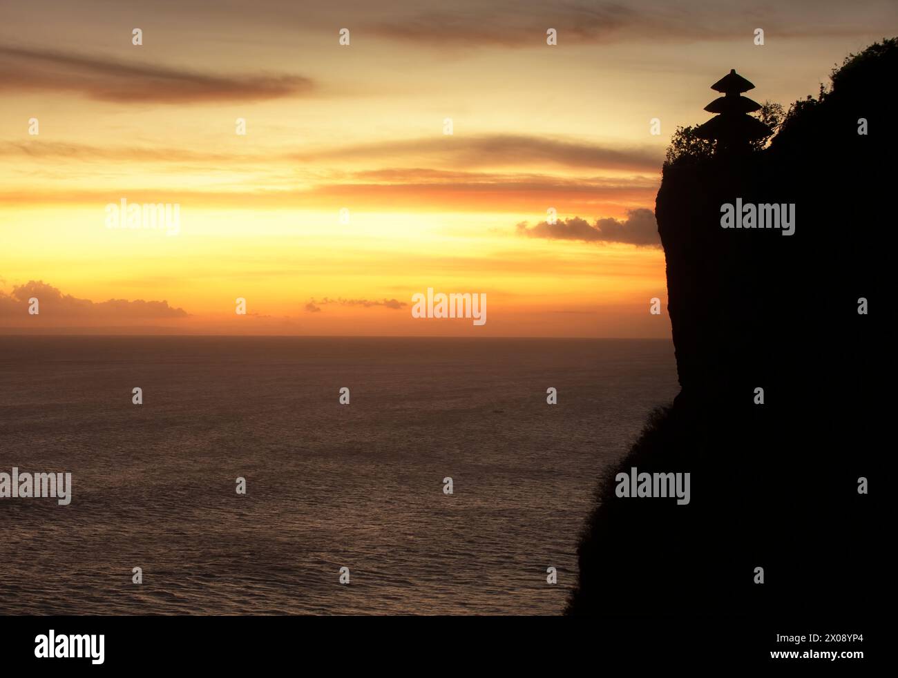 The silhouette of a tiered temple on a clifftop against the backdrop of ...