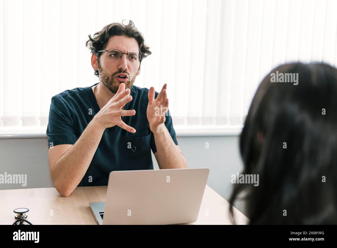A medical doctor is shown mid-discussion, using hand gestures to ...