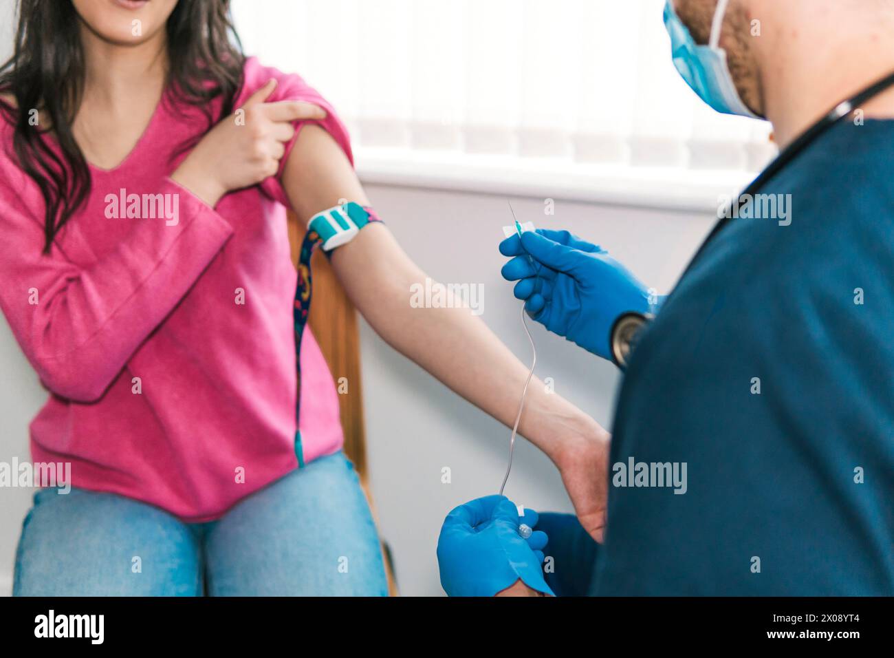 Anonymous healthcare professional prepares to draw blood from a patient ...