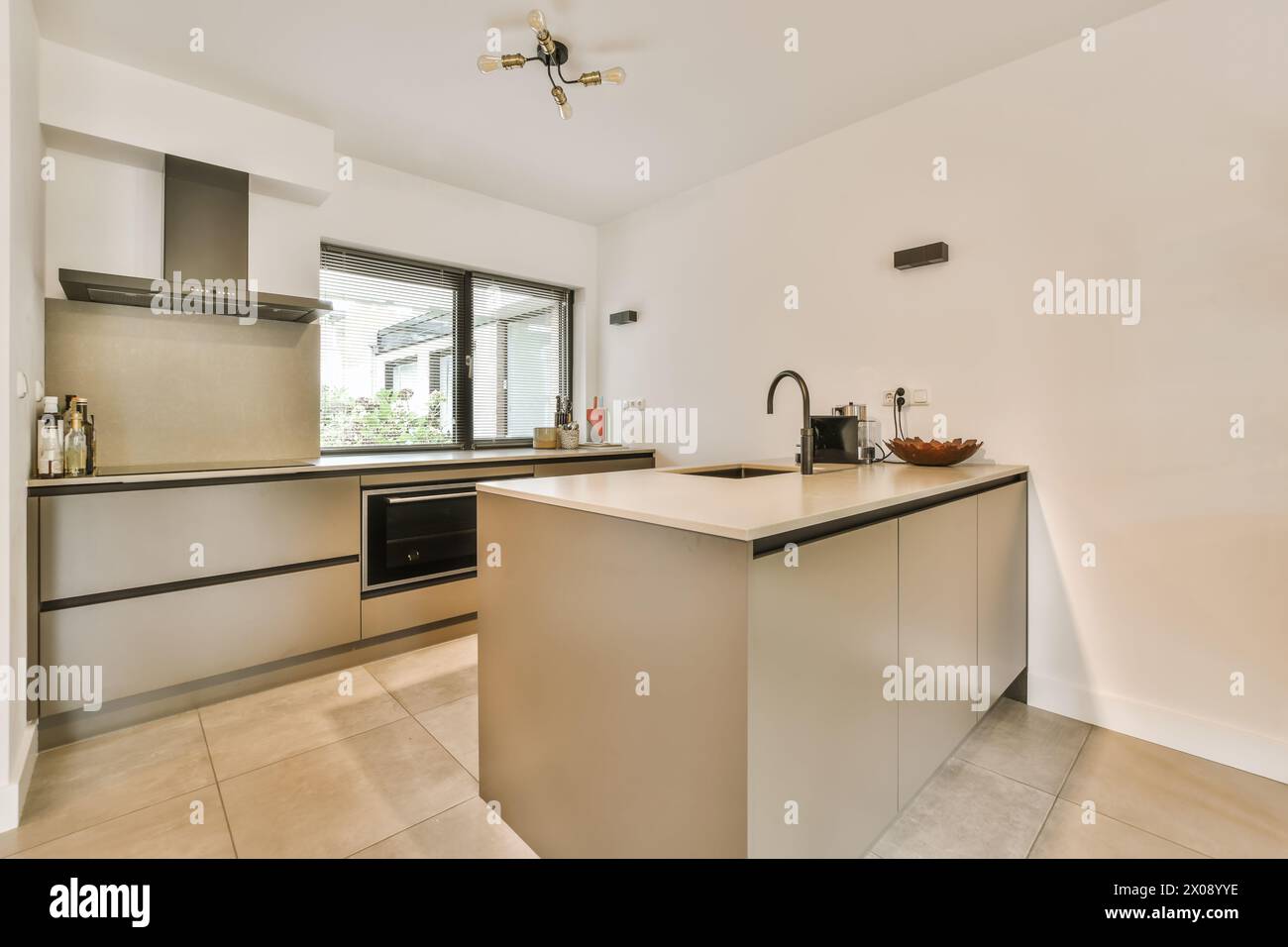 A contemporary kitchen design featuring a central island, sleek ...