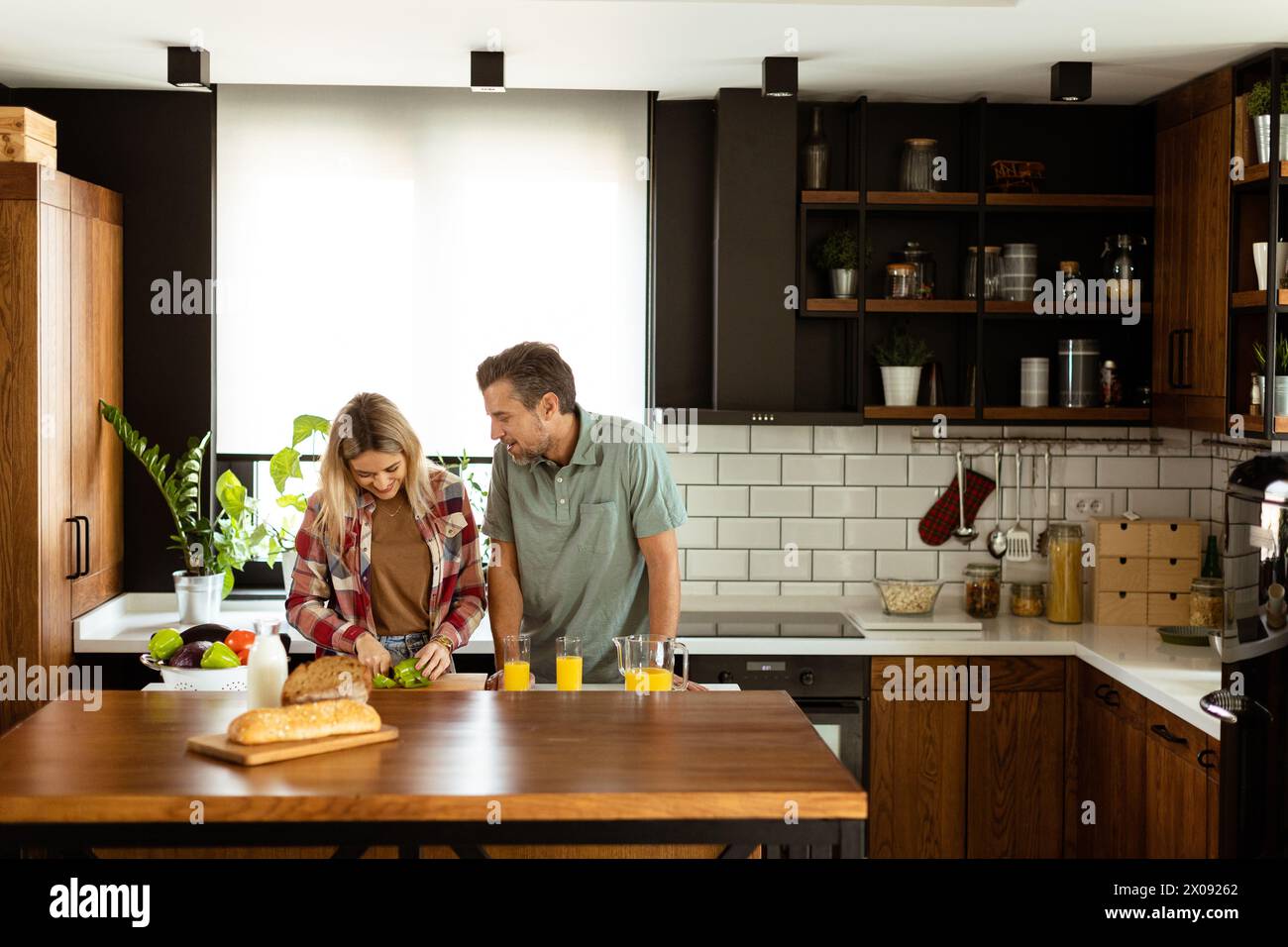 A happy couple enjoys a casual conversation with morning drinks in ...