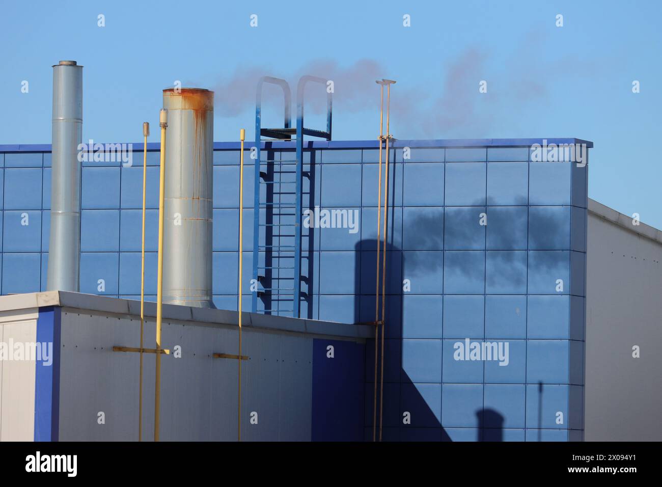 Industrial chimney, low angle view. Chimney with smoke, stairs, wall ...