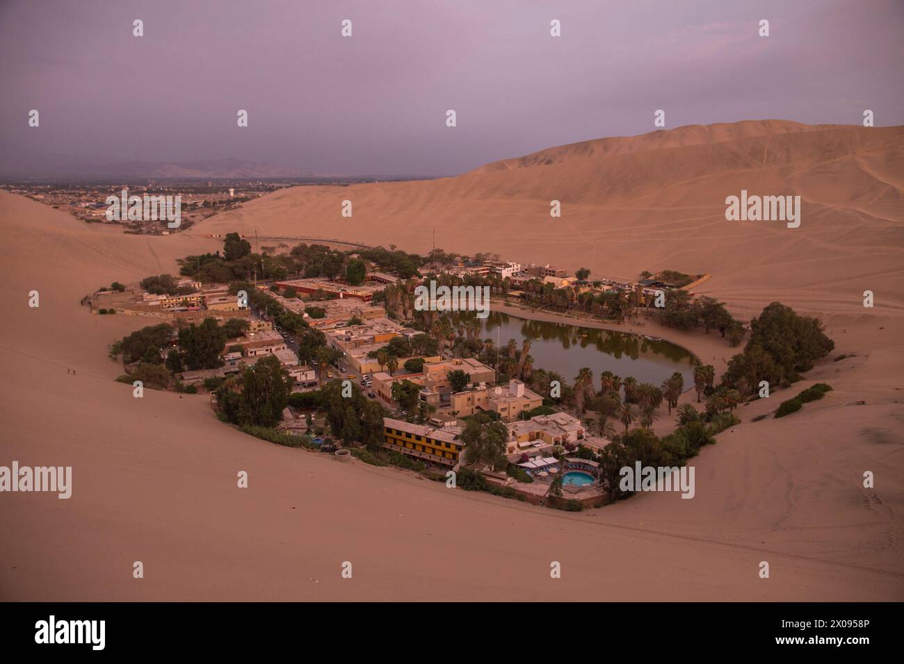 Huacachina oasis, a popular tourism destination, sits amongst expansive ...