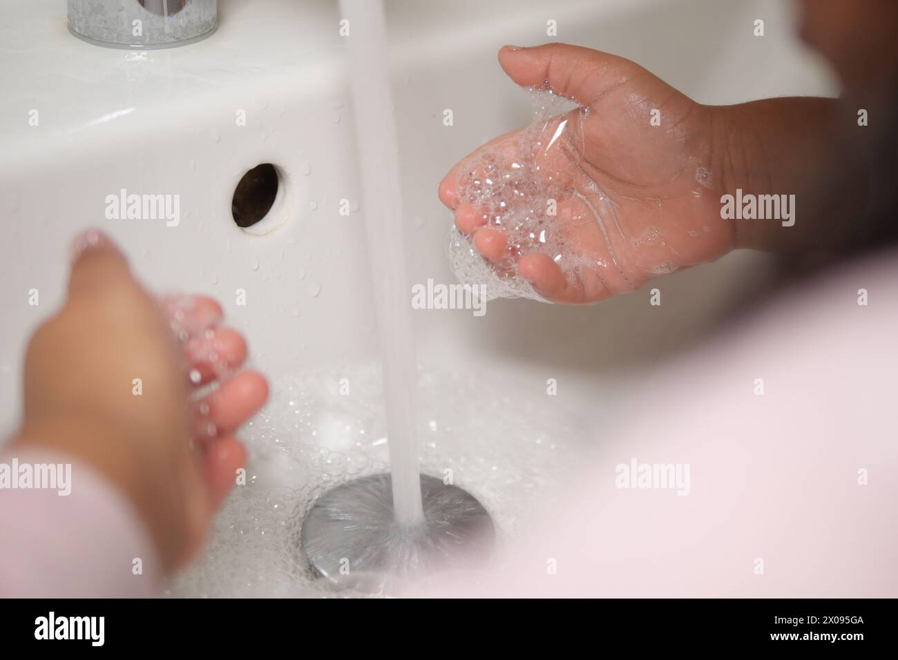 kid making a cleansing gesture with soap and water on hands Stock Photo ...