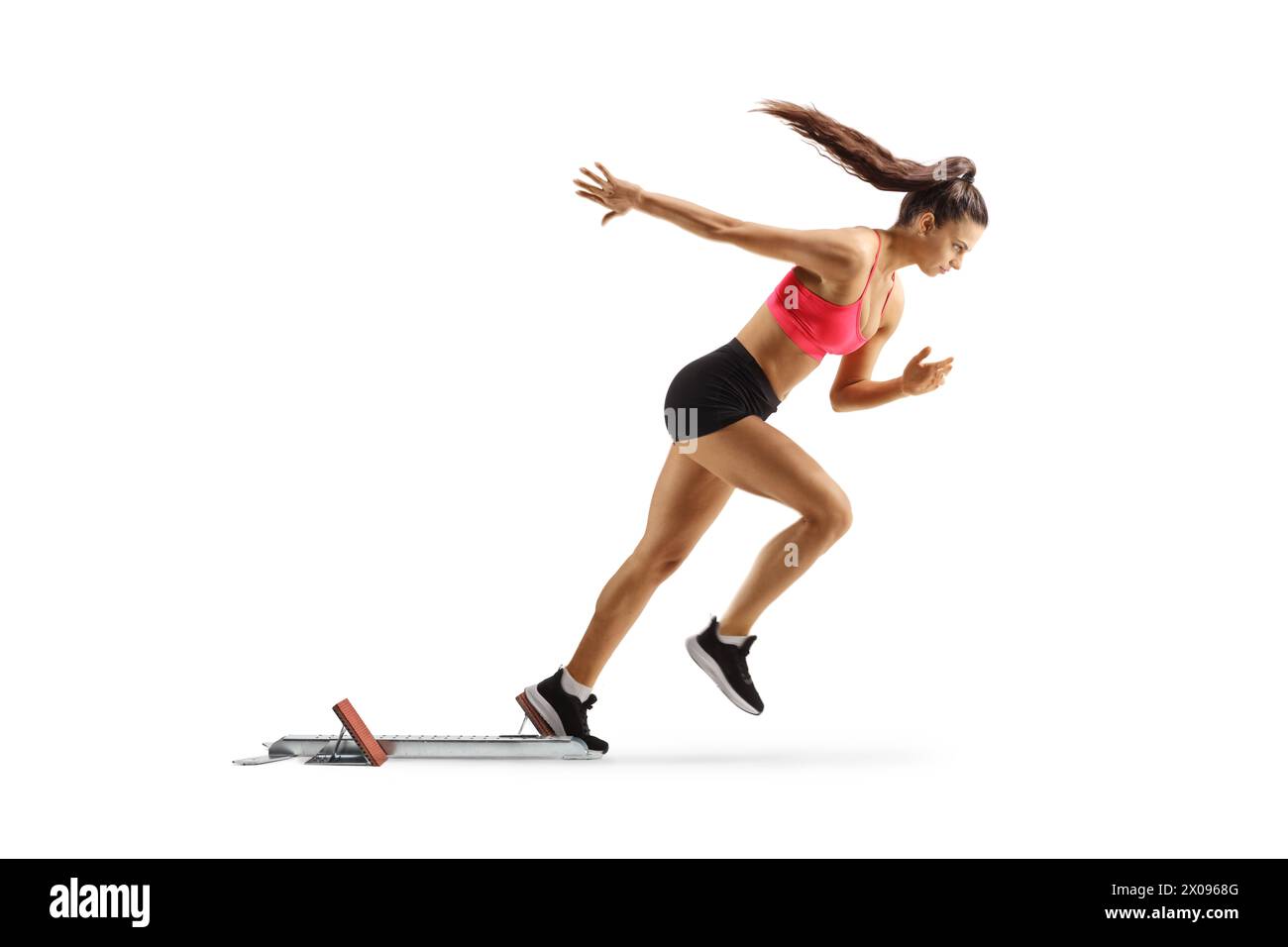 Full length profile shot of a female runner on a starting block ...