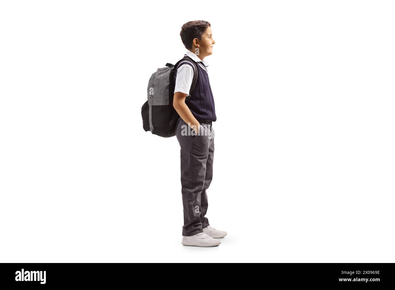 Full length profile shot of a schoolboy in a uniform standing with ...
