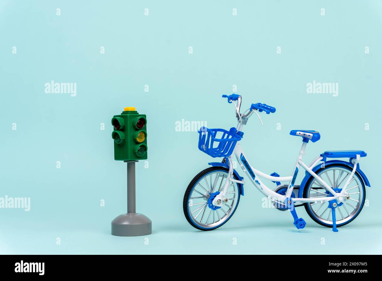 A miniature toy bike positioned next to a traffic light, symbolizing the importance of road ...