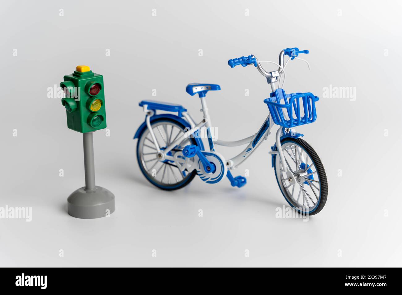 A miniature toy bike positioned next to a traffic light, symbolizing the importance of road ...