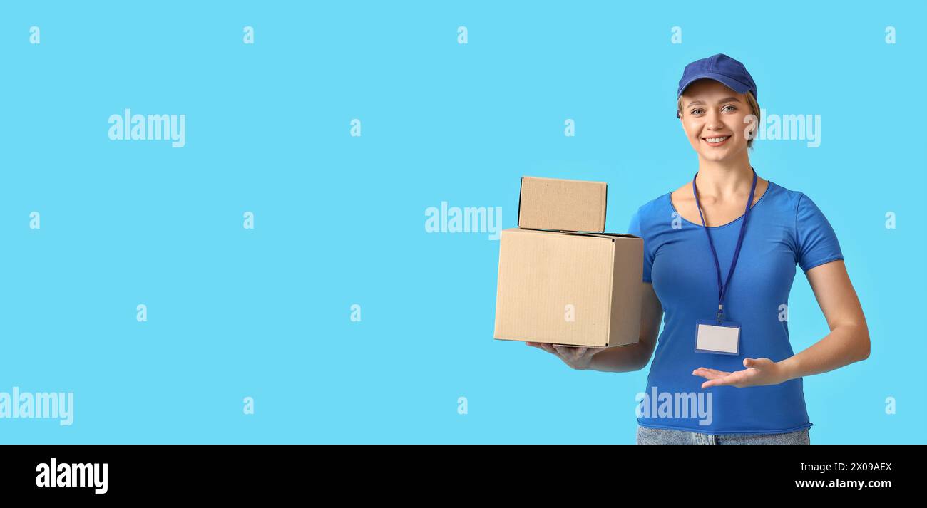 Female courier holding parcels on blue background with space for text ...