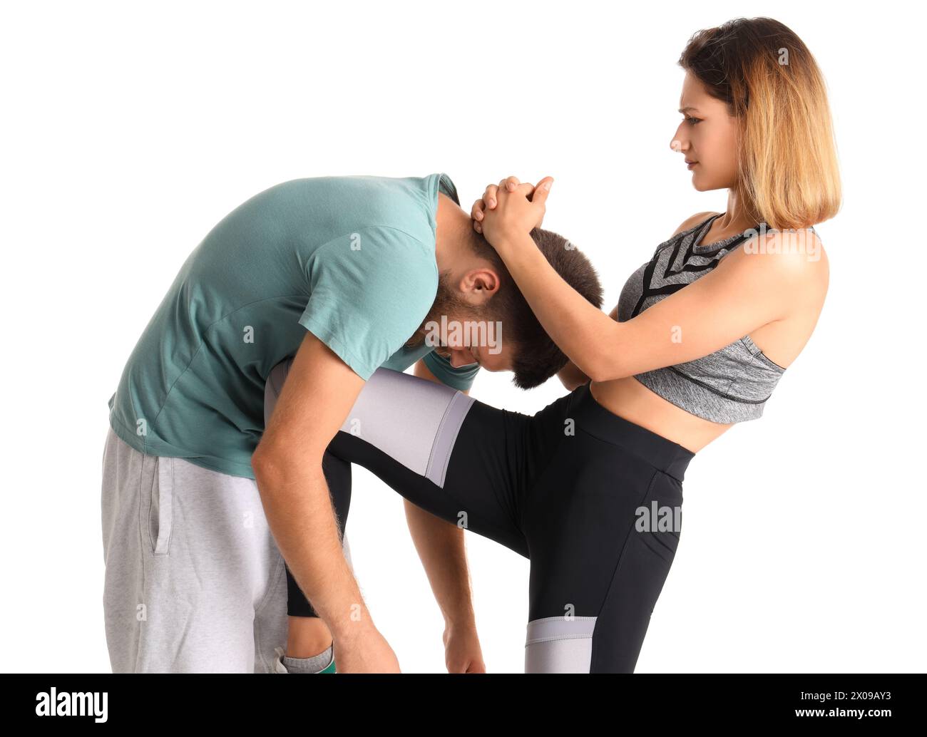 Young woman fighting with instructor of self-defence course on white ...