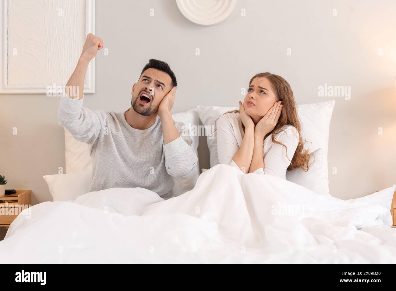 Young couple suffering from loud neighbours in bedroom Stock Photo - Alamy