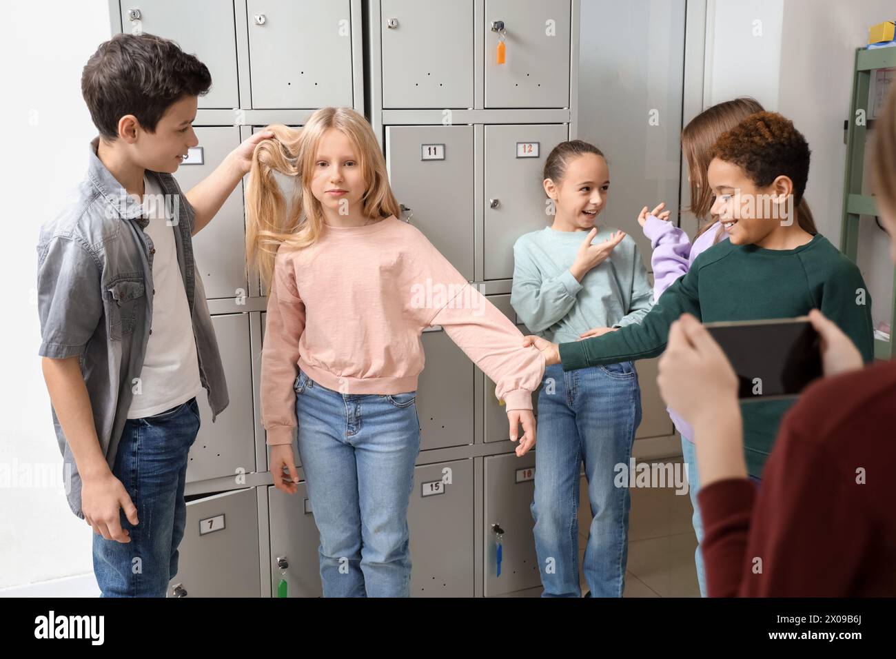 Classmates bullying little girl near locker at school Stock Photo - Alamy