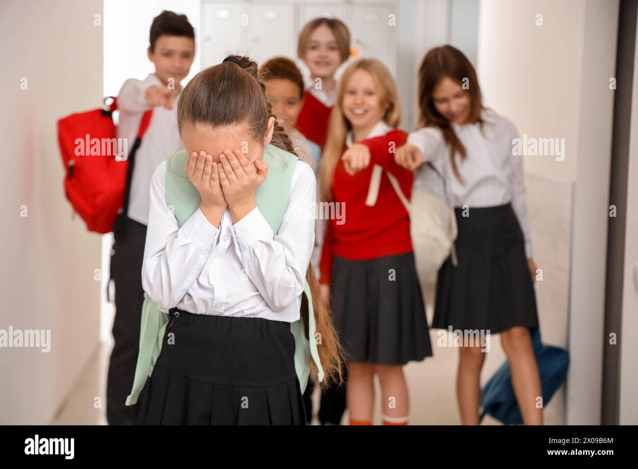 Bullied little girl crying at school hall Stock Photo - Alamy