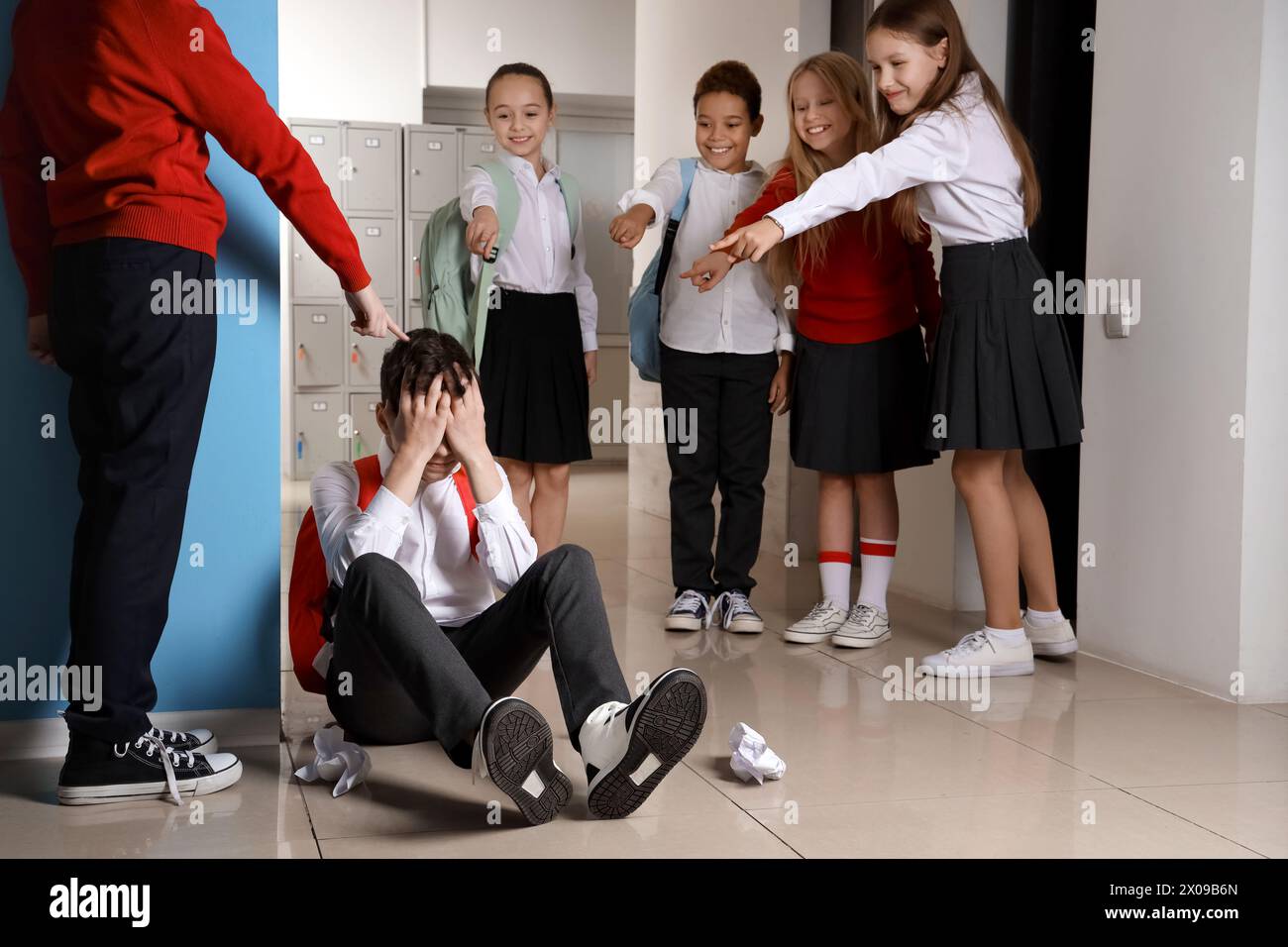 Classmates bullying little boy at school hall Stock Photo - Alamy