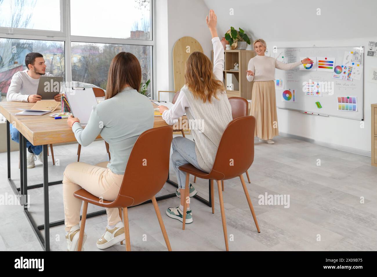 Mature art teacher giving lecture to students at school Stock Photo - Alamy