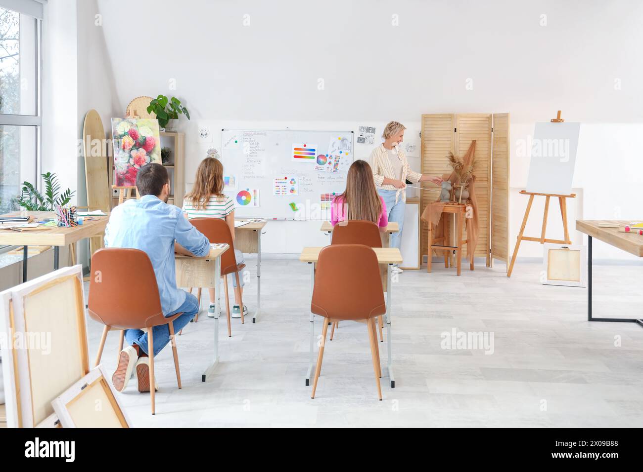 Female art teacher giving lesson to students at school Stock Photo - Alamy