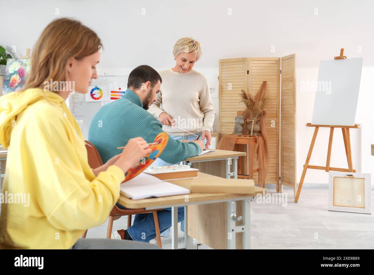 Female art teacher helping student at school Stock Photo - Alamy