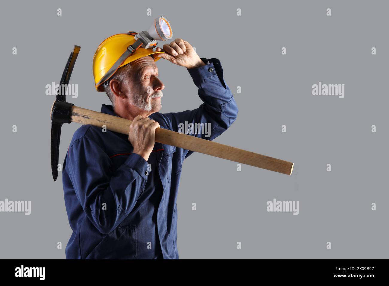 Mature miner man with pick axe on grey background Stock Photo - Alamy
