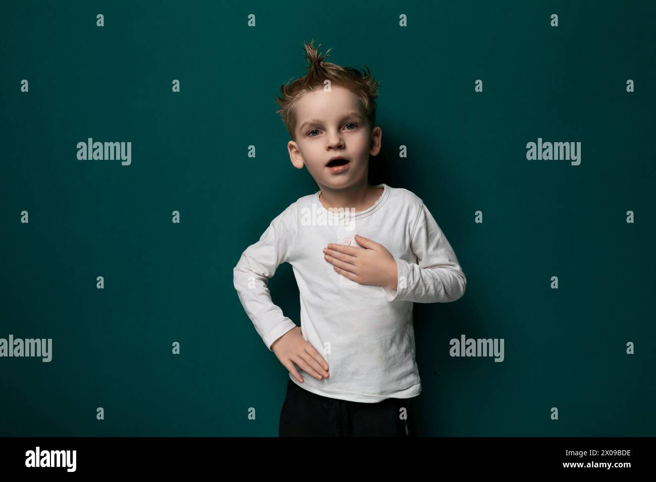 Young Boy Standing in Front of Green Wall Stock Photo - Alamy