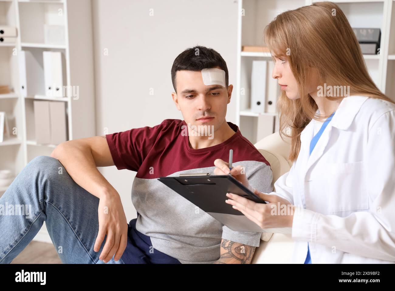 Female doctor examining man with brain concussion in clinic Stock Photo ...