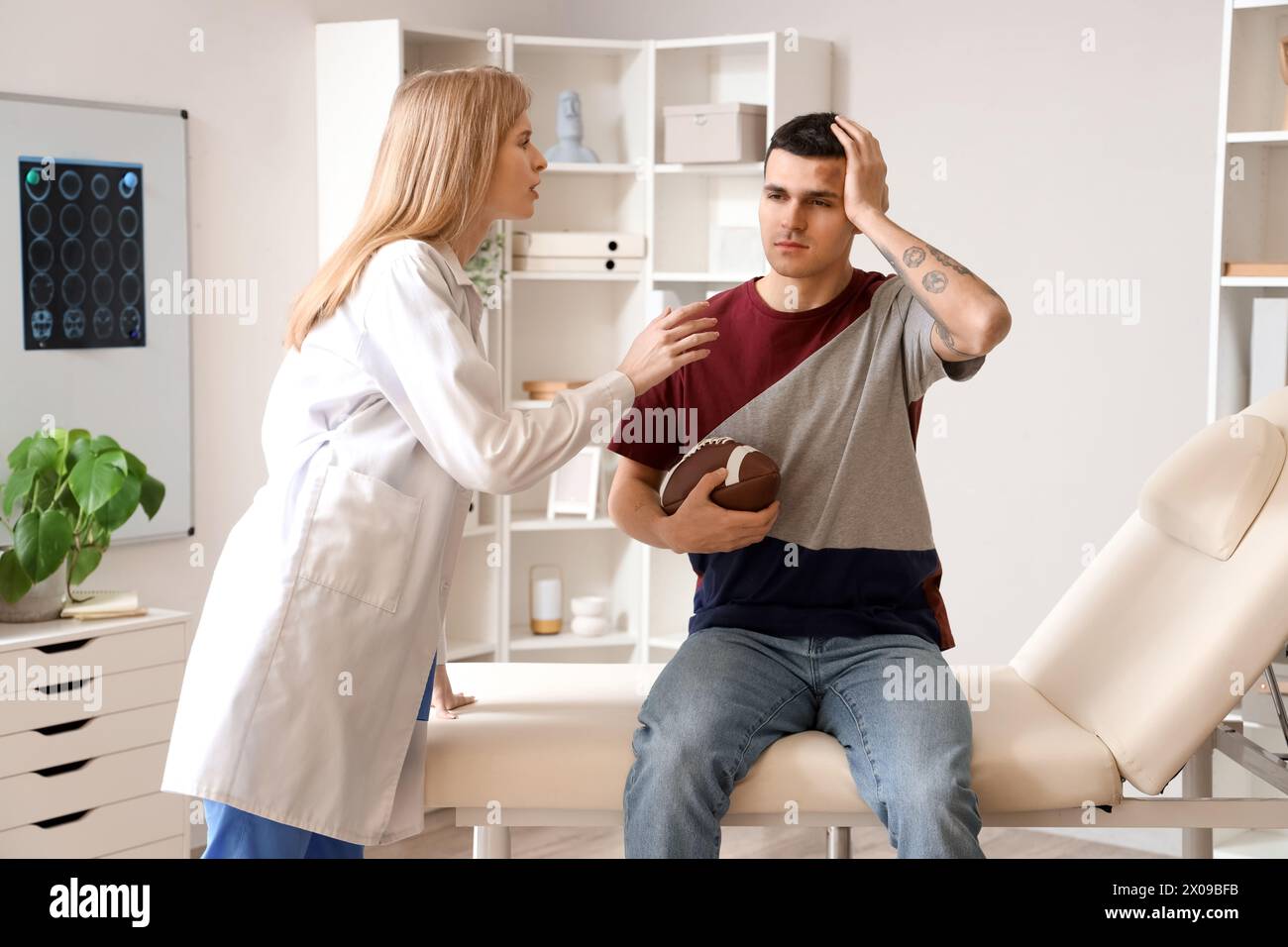 Female doctor examining rugby player with brain concussion in clinic ...