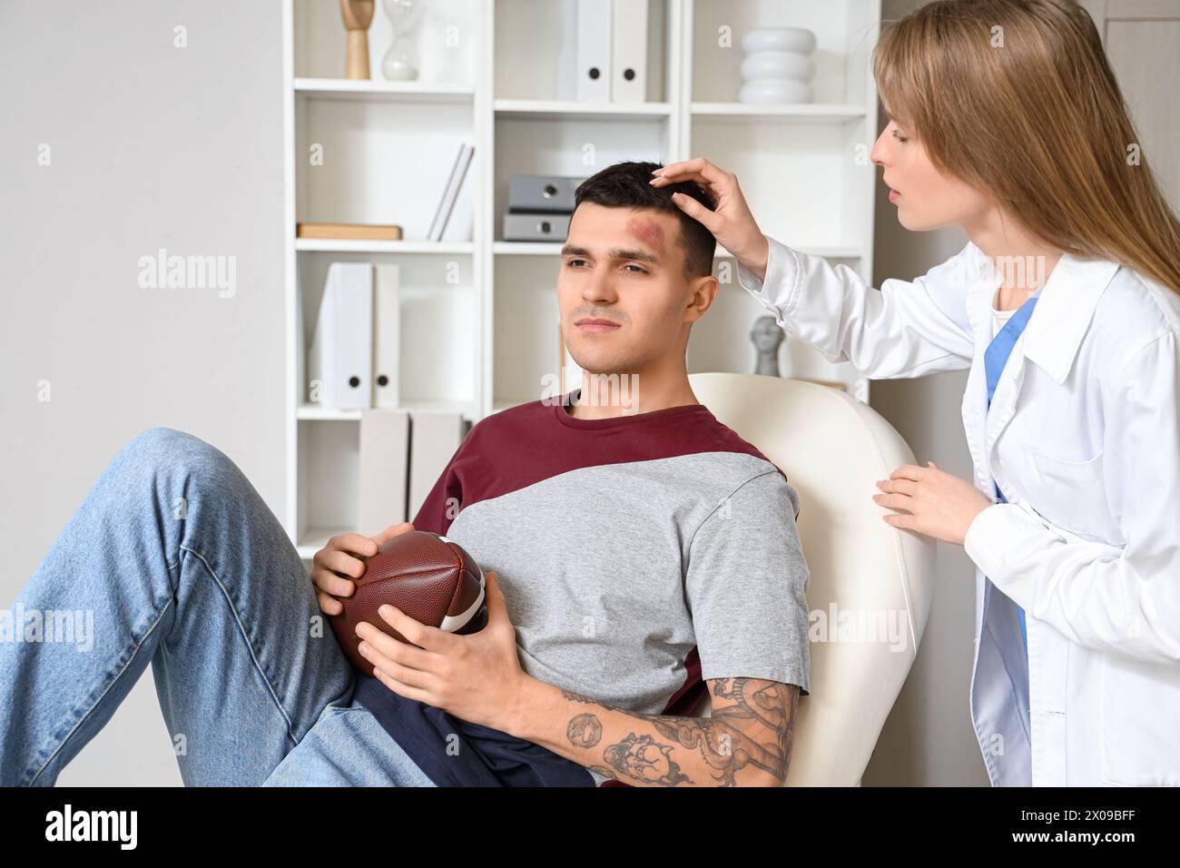 Female doctor examining rugby player with brain concussion in clinic ...