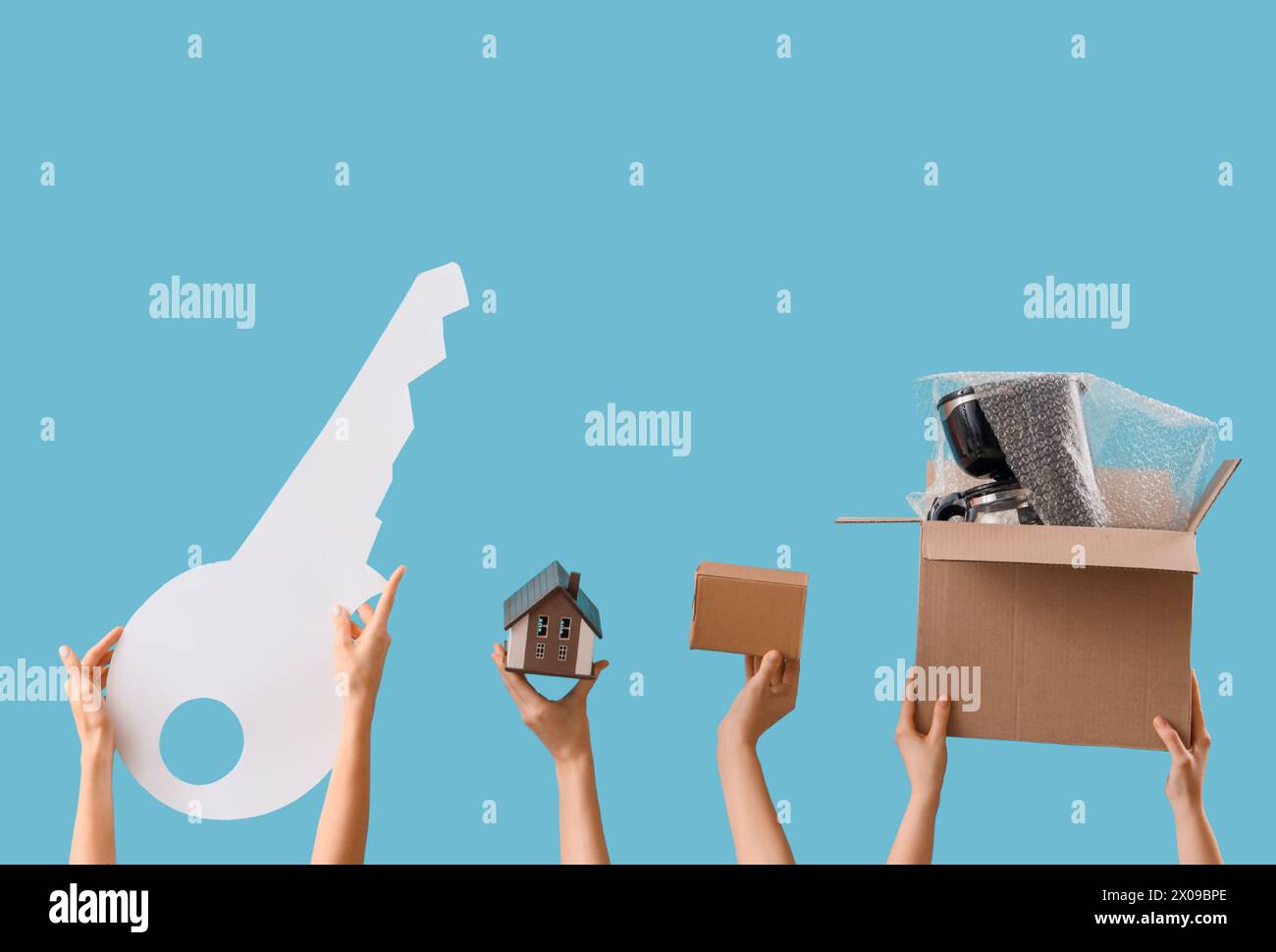 Women with moving boxes, house model and paper key on blue background ...