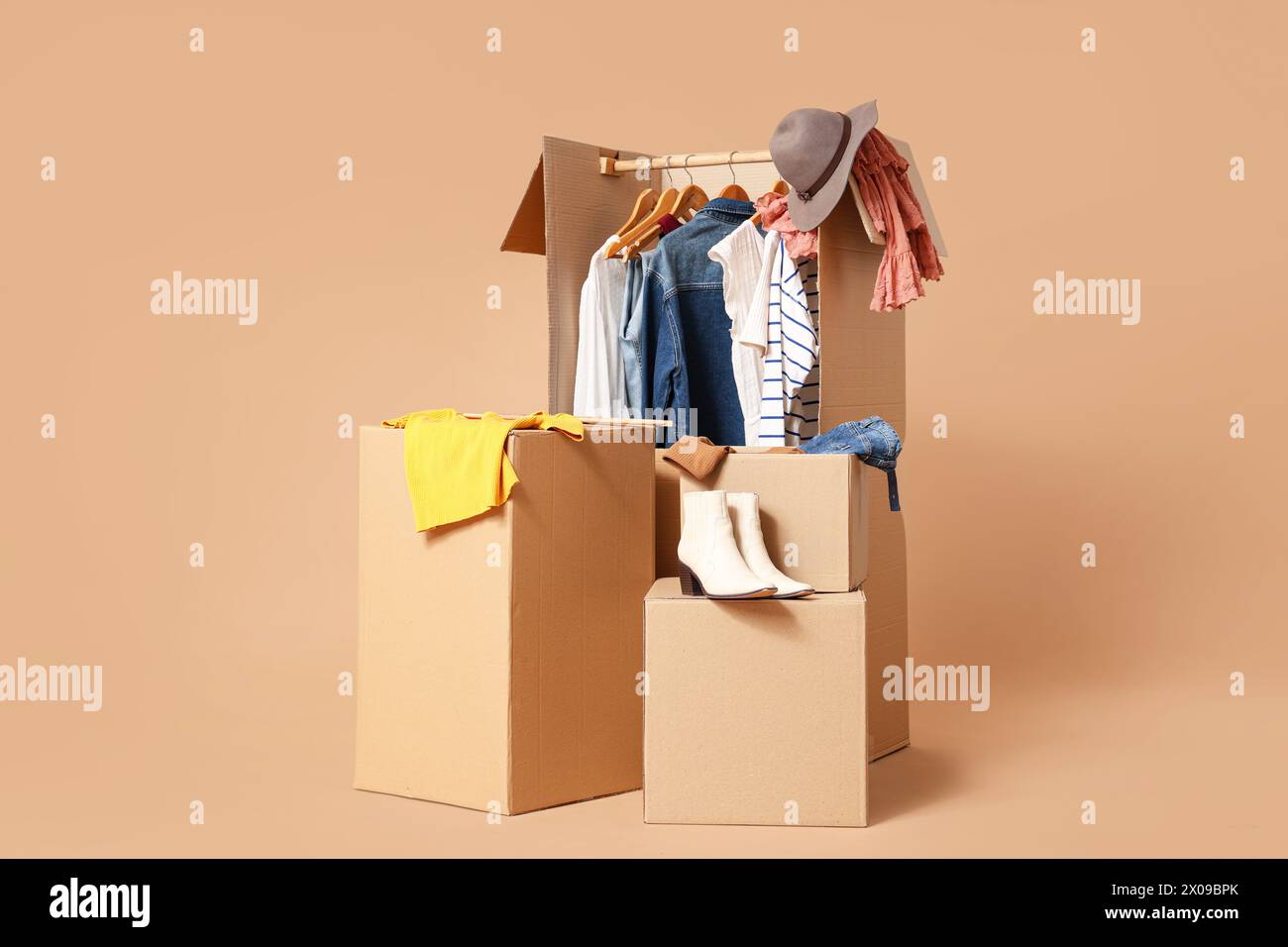 Wardrobe boxes with clothes on beige background Stock Photo - Alamy