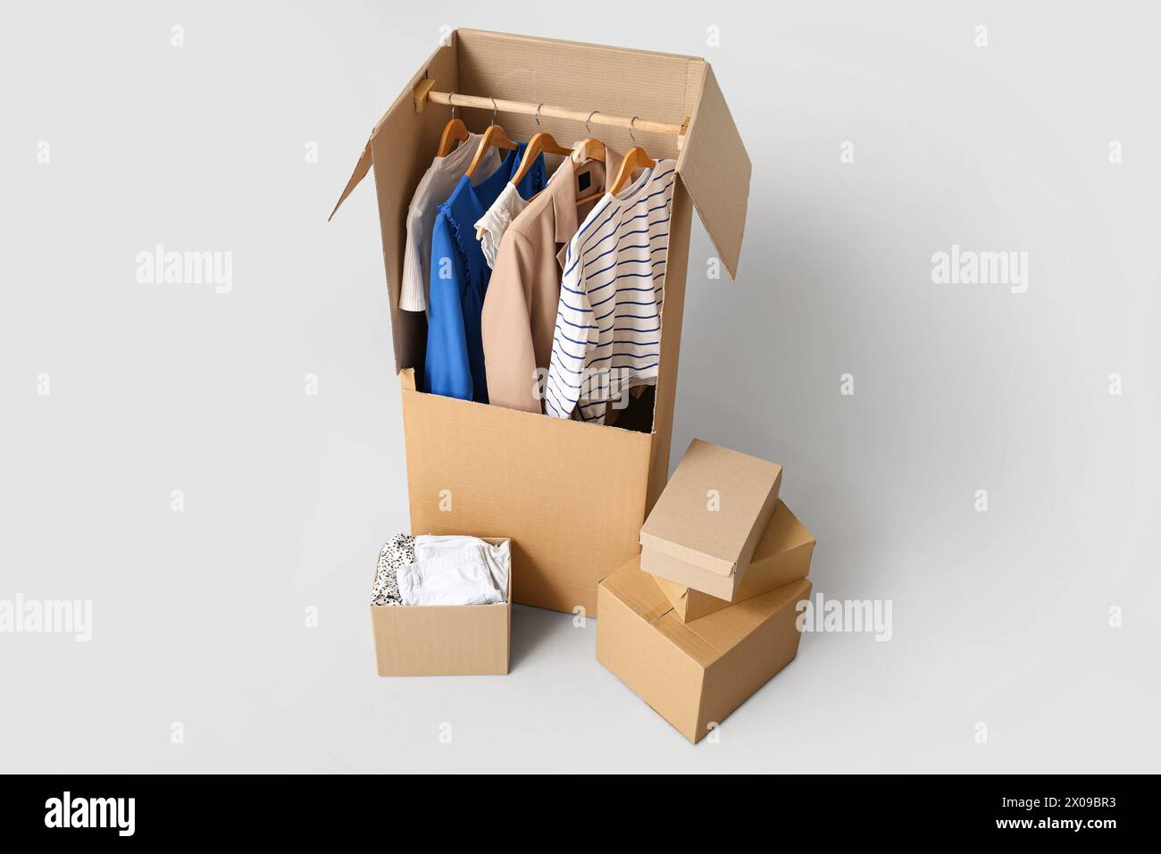 Wardrobe boxes with clothes on grey background Stock Photo - Alamy