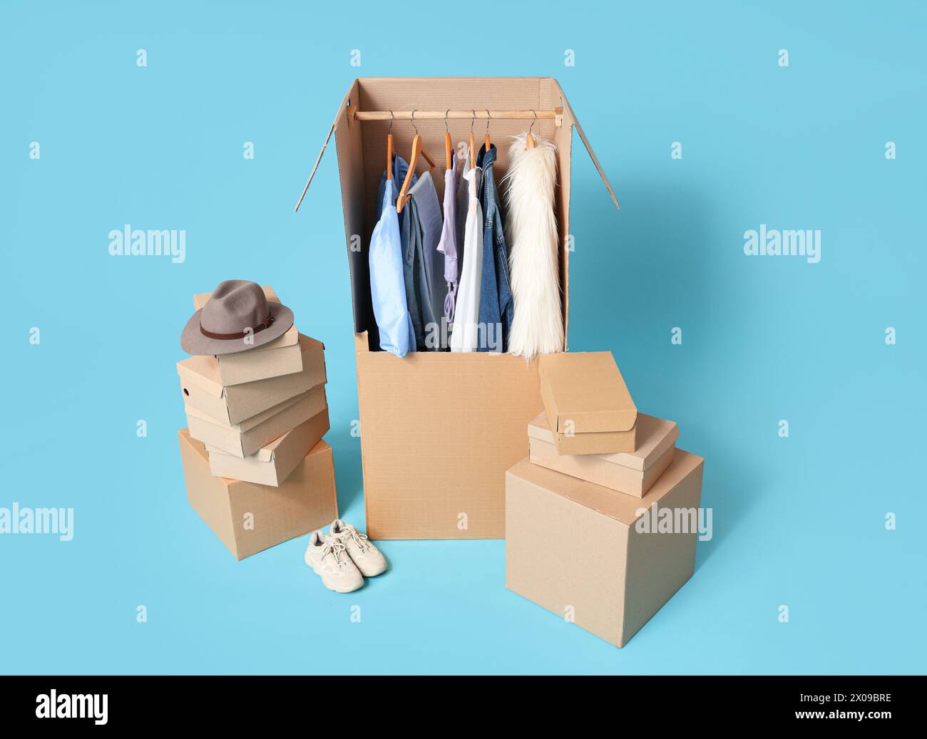 Wardrobe boxes with clothes on blue background Stock Photo - Alamy