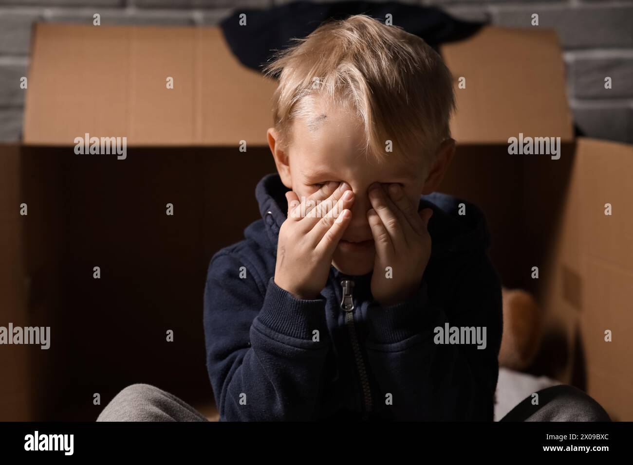 Homeless little boy crying near cardboard box, closeup Stock Photo - Alamy