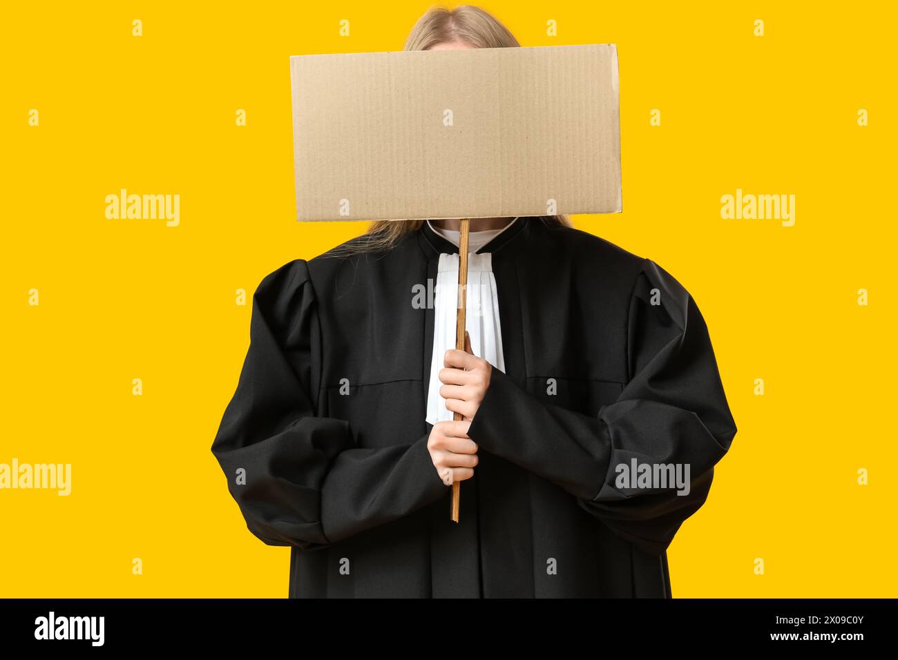 Protesting female judge holding blank placard on yellow background ...