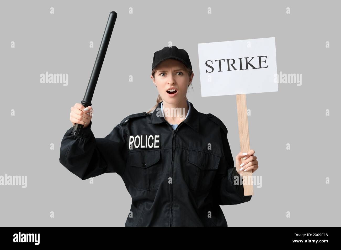 Protesting female police officer holding baton and placard with text ...