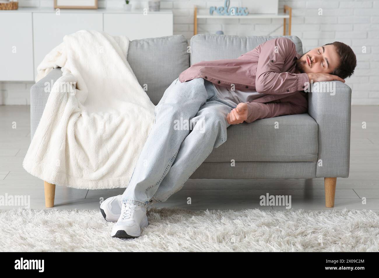Depressed man sleeping on sofa hi-res stock photography and images - Alamy