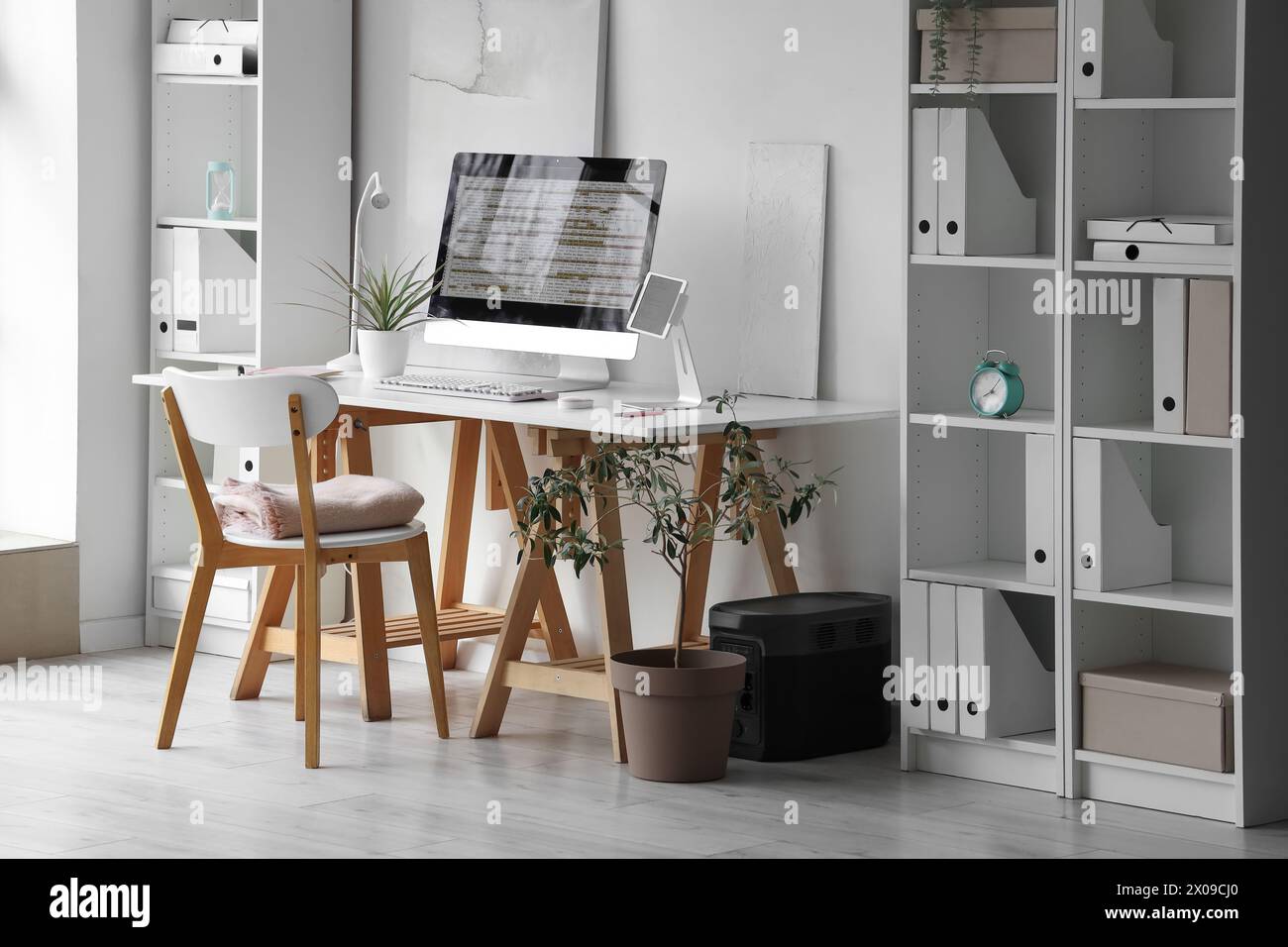 Interior of stylish office with programmer's workplace and shelf units ...