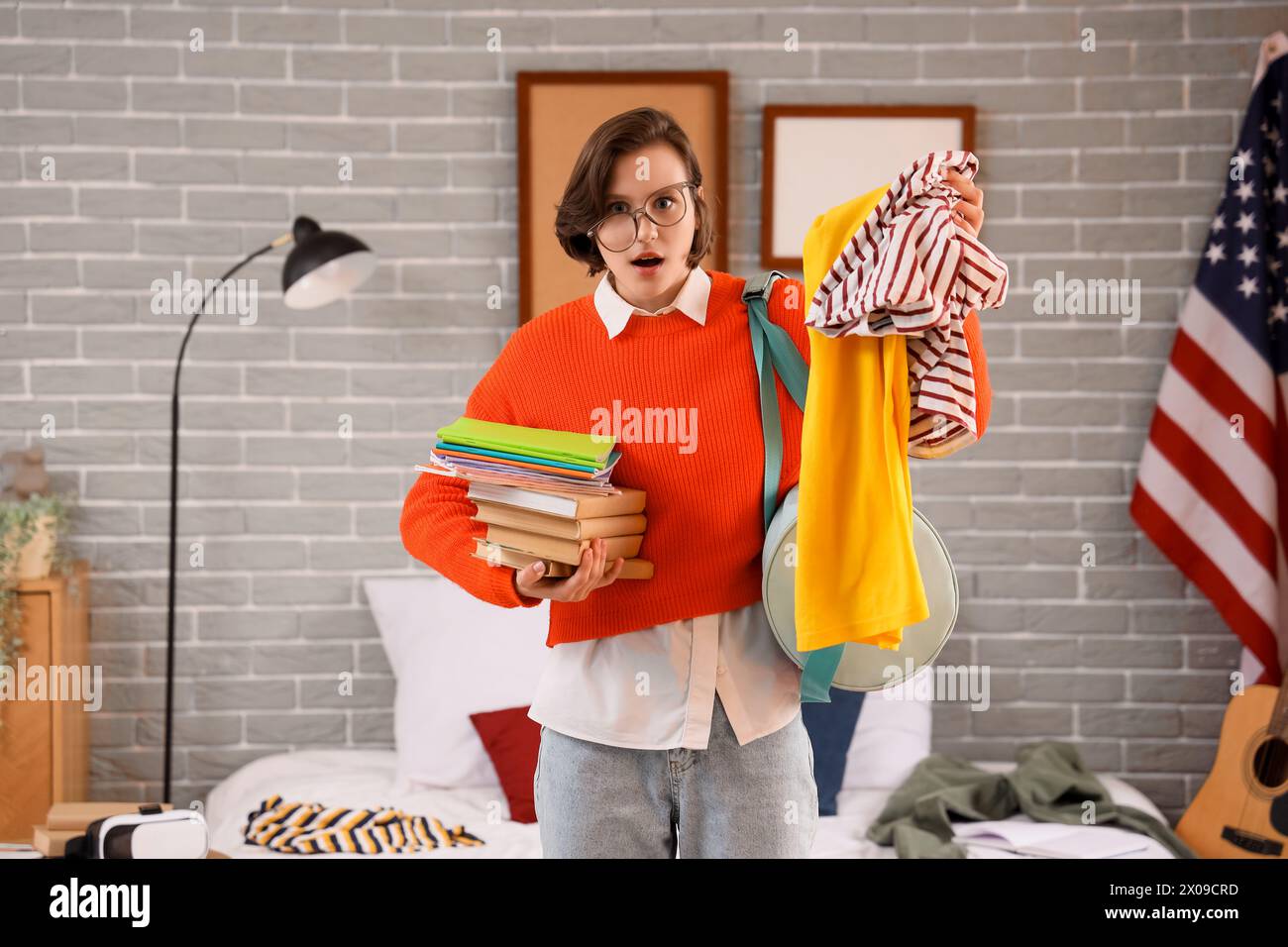 Stressed female student with books and clothes in bedroom Stock Photo ...
