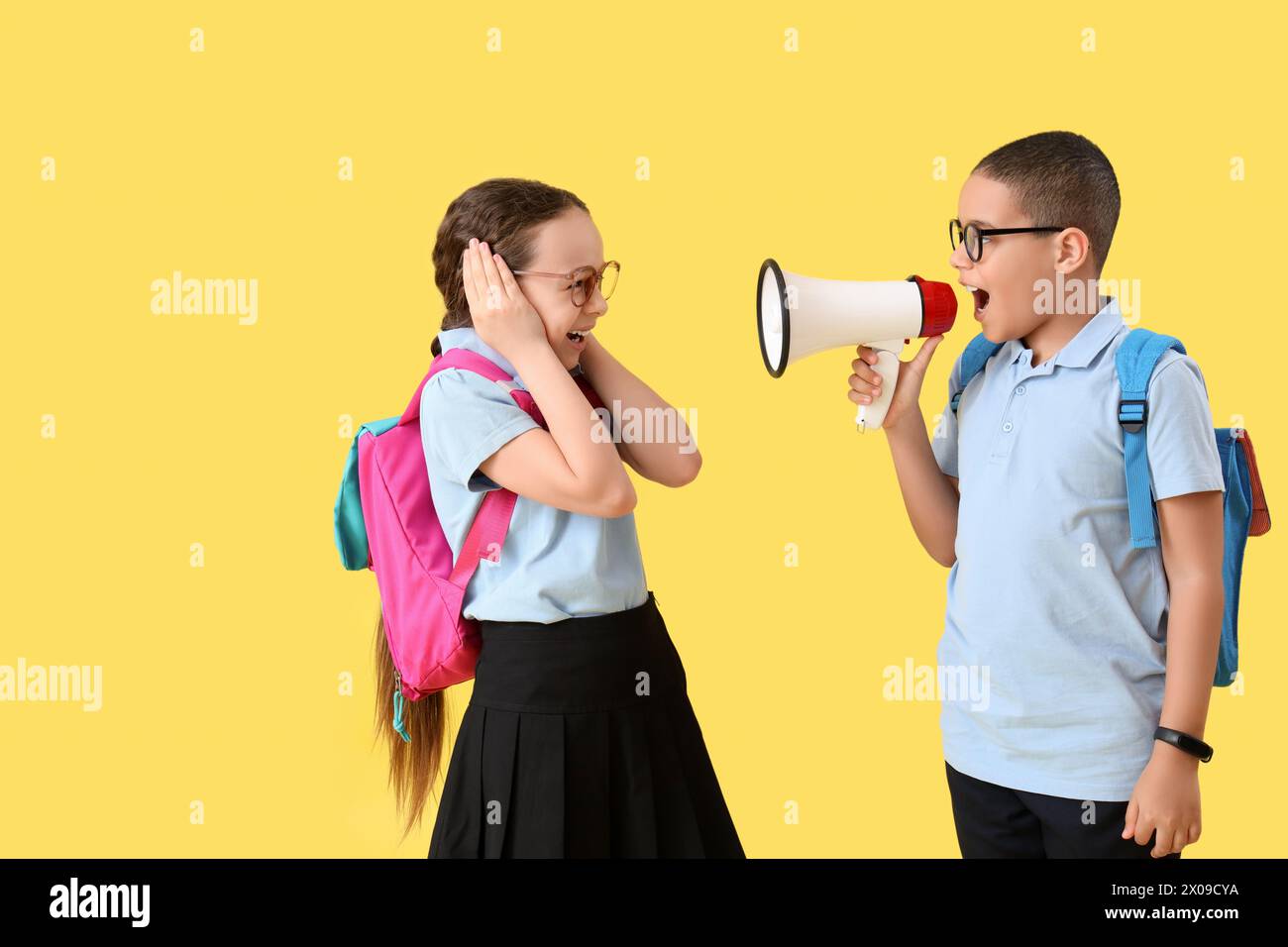 Funny little pupils with backpacks and megaphone screaming on yellow ...