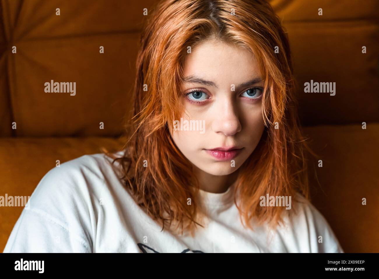A charming red-haired teenage girl with a bright smile poses for a ...