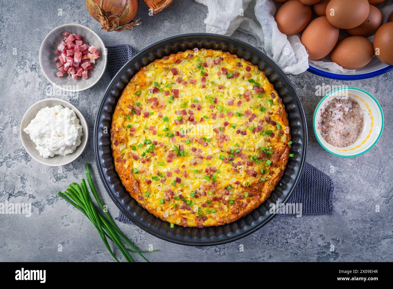 Homemade oven baked frittata with curd cheese, bacon, onion and chives ...