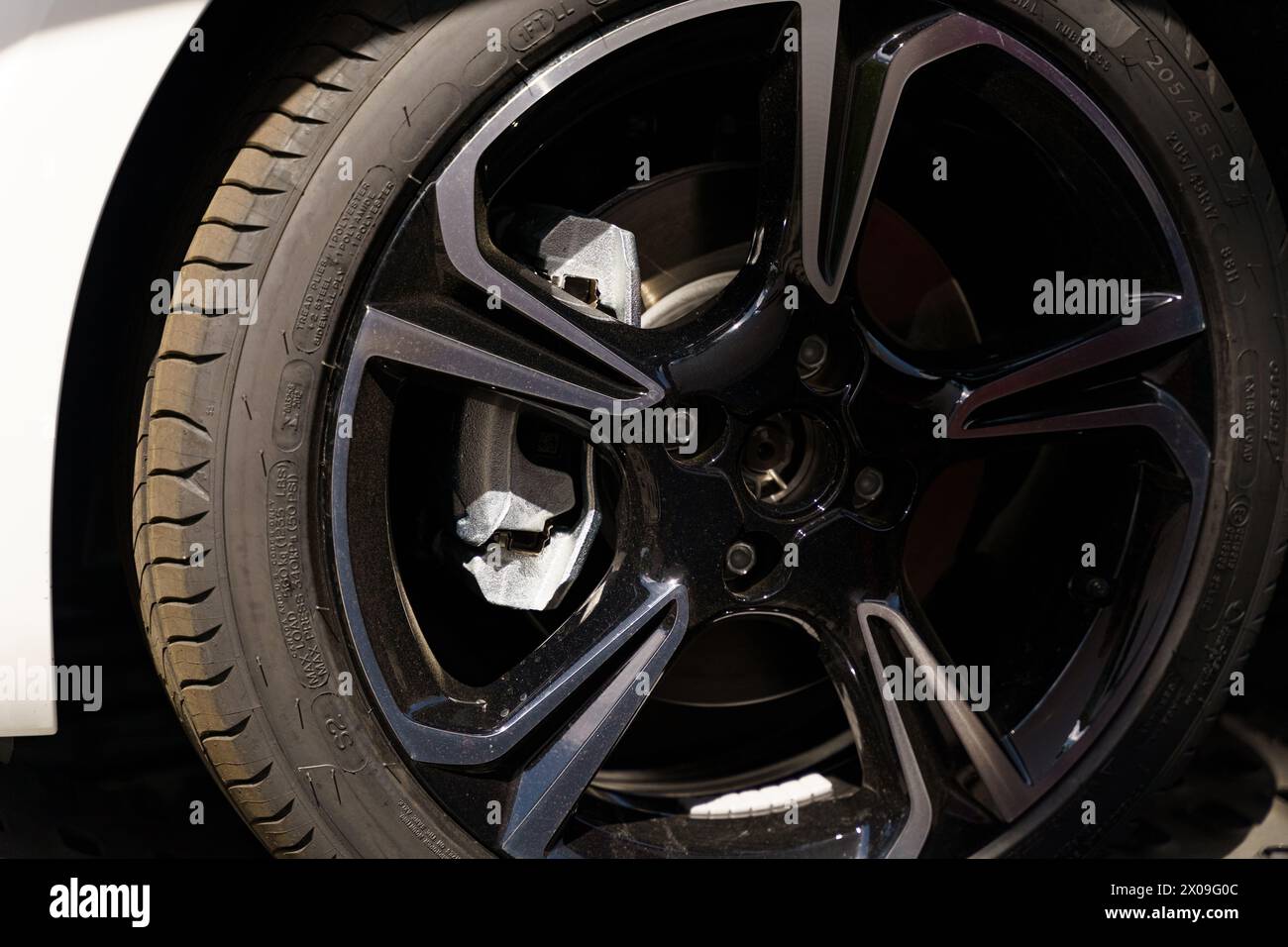 Up-close view of a shiny white car tire with intricate tread patterns ...