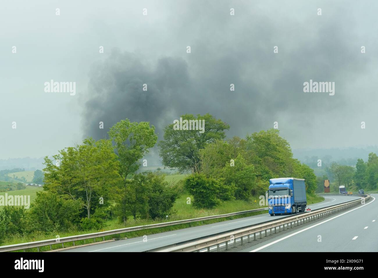 A significant amount of black smoke billowing into the sky from the ...