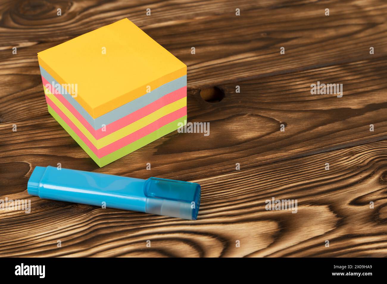 A stack of colorful notes, reminder stickers and a blue marker on a ...