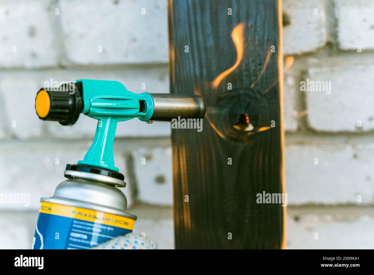 firing of a wooden board with a portable burner and a gas cylinder ...