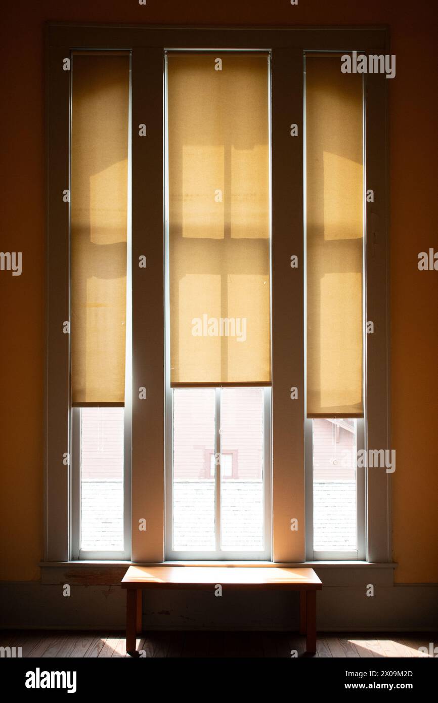 Small bench in front of dramatic bright windows Stock Photo - Alamy