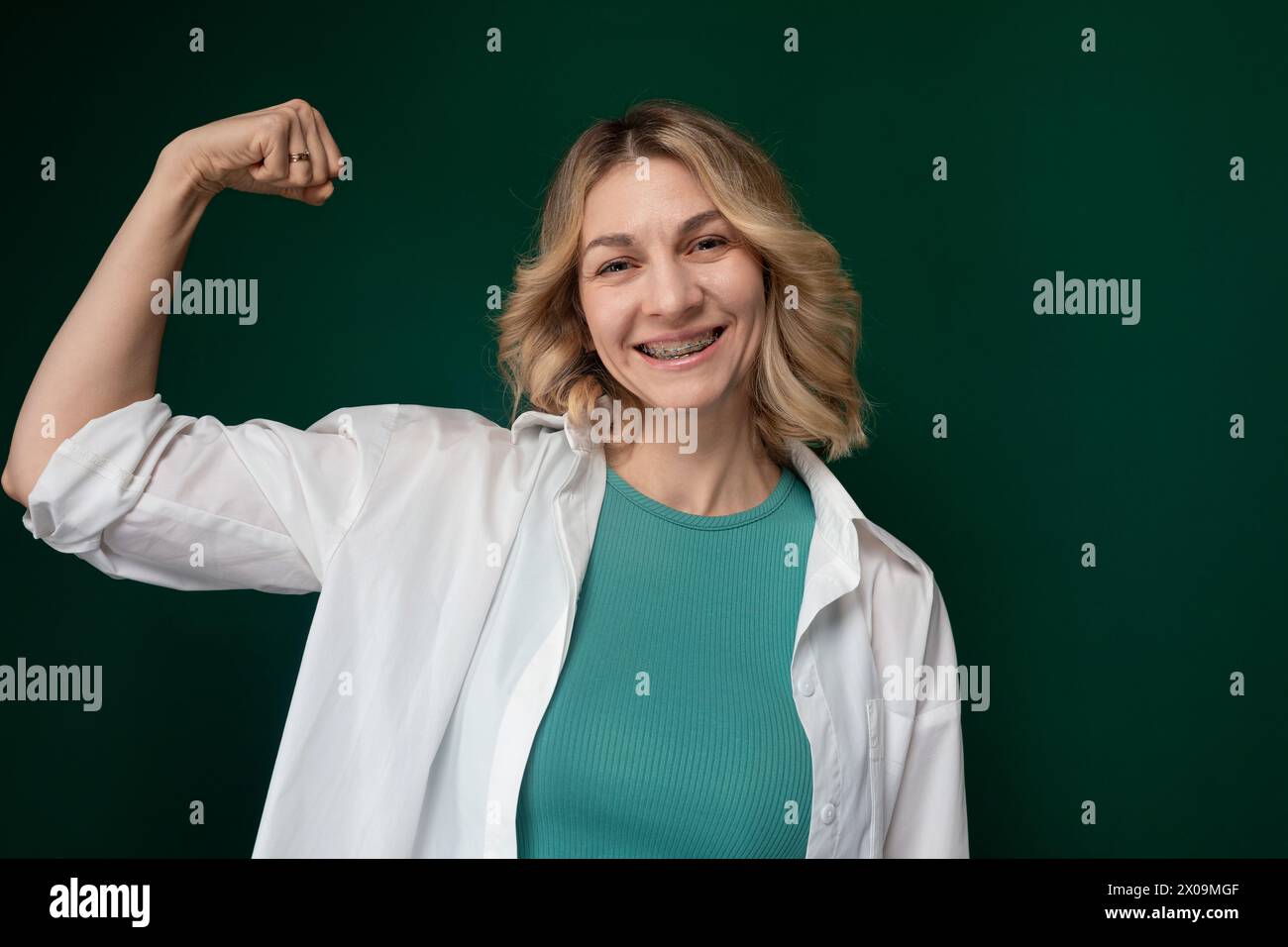 Woman flexing arm green shirt hi-res stock photography and images - Alamy