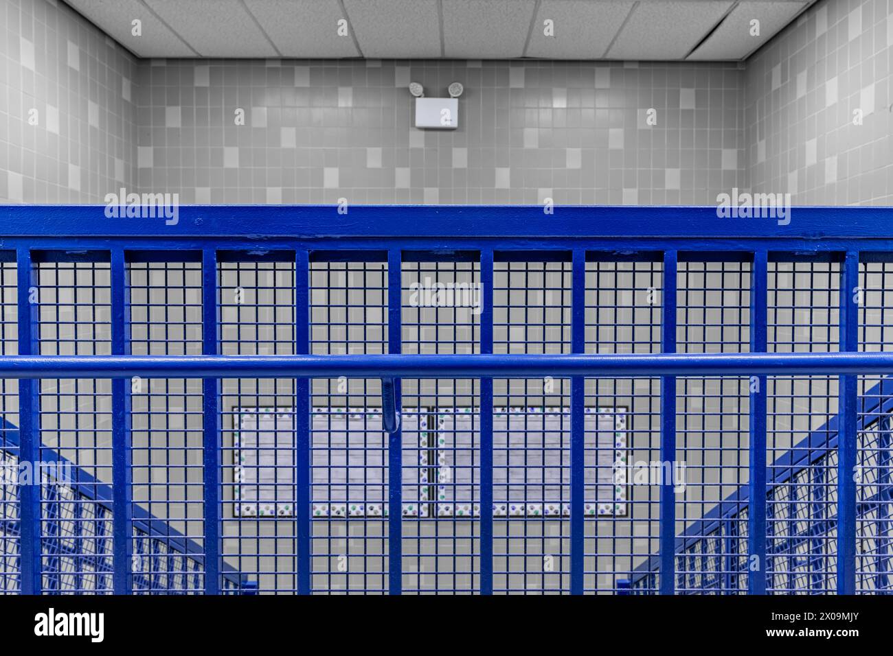 Close-up photo of a blue metal railing at the top of a school staircase ...