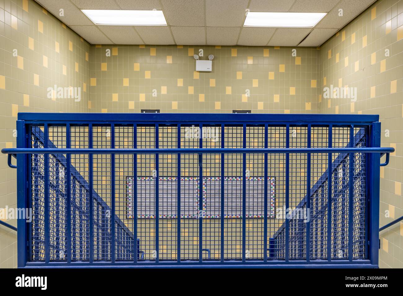 Close-up photo of a blue metal railing at the top of a school staircase ...