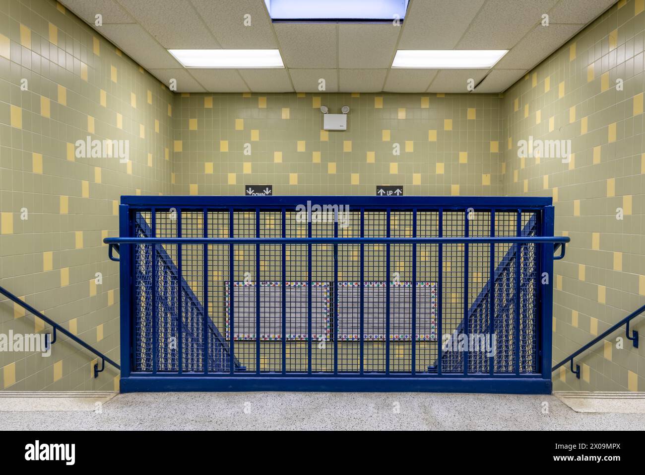 Close-up photo of a blue metal railing at the top of a school staircase ...